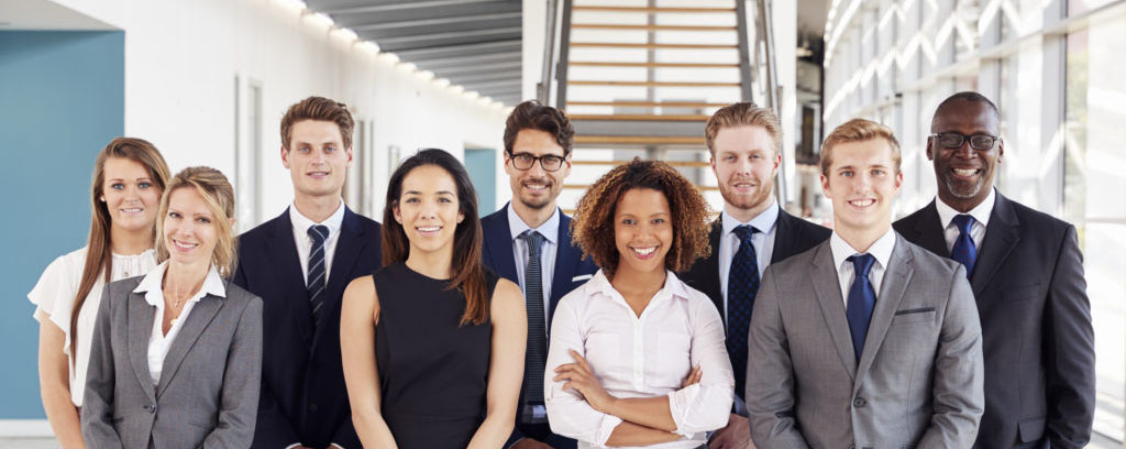 Office workers in a modern lobby, group portrait | Dapper Companies